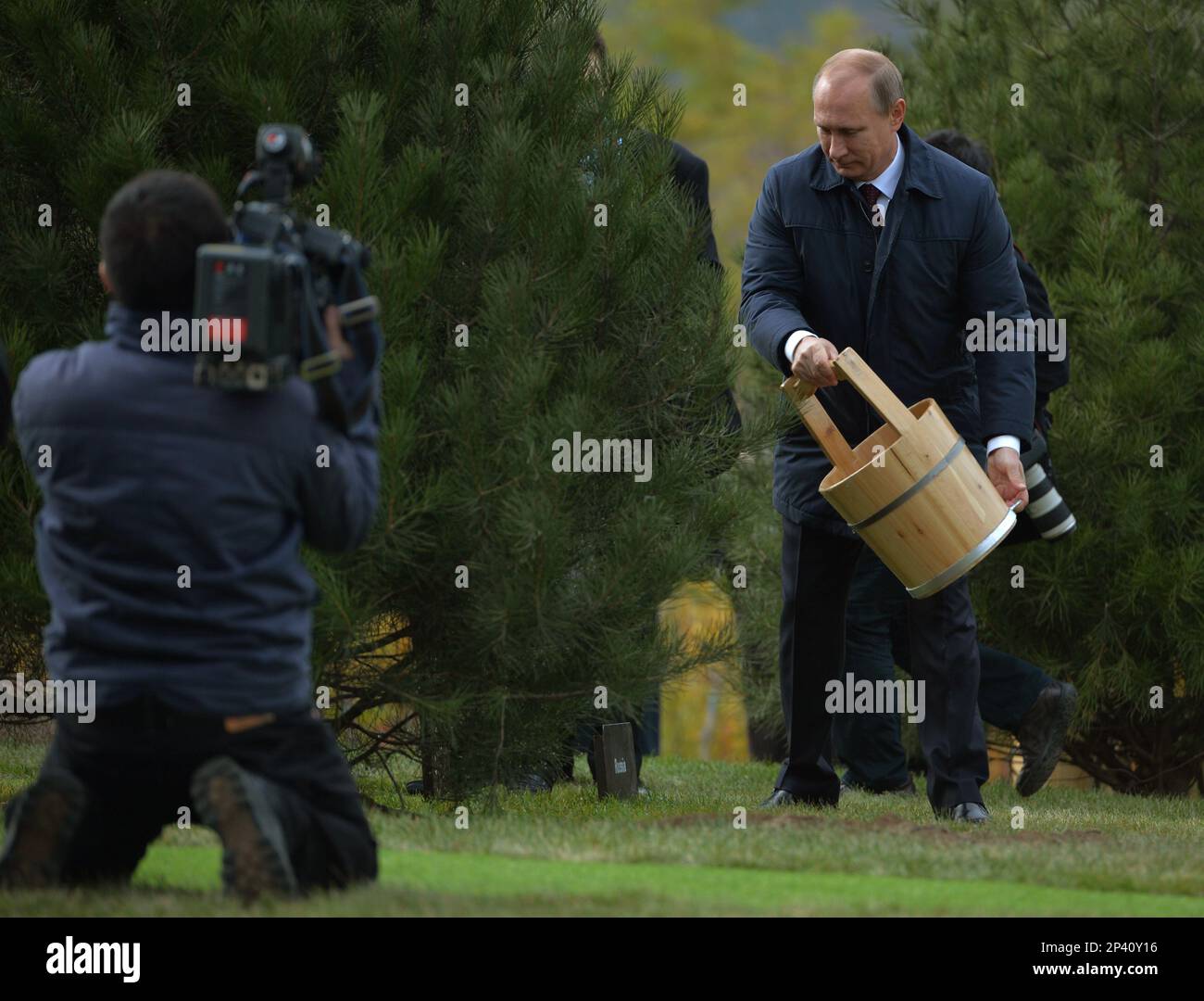 Russian President Vladimir Putin waters the just planted tree as he ...