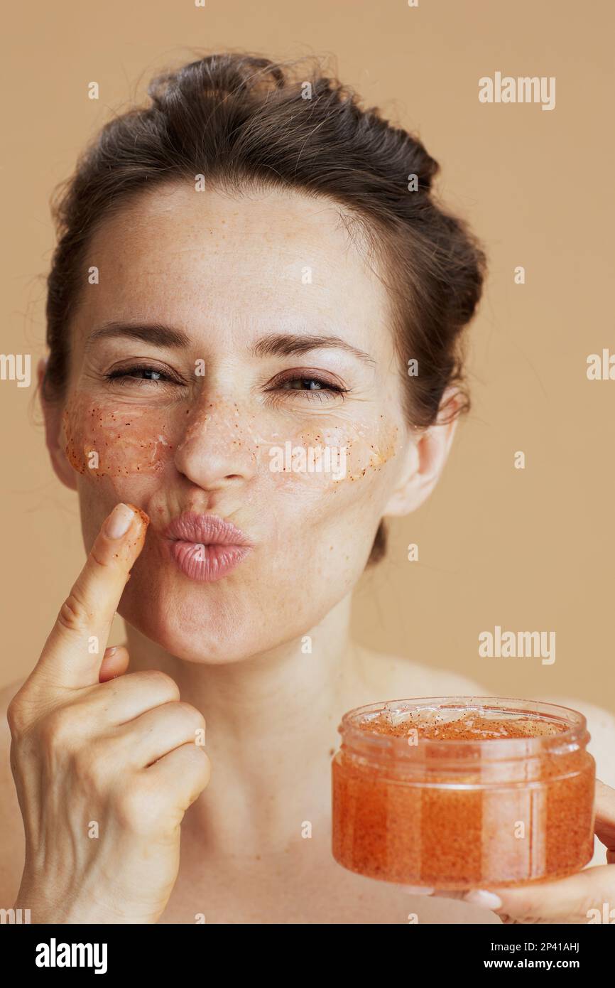 young woman with face scrub on beige background Stock Photo - Alamy