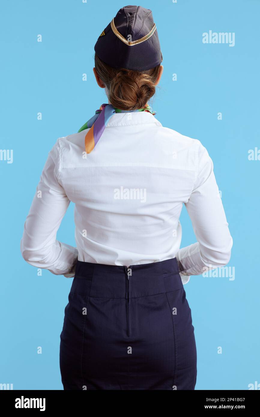 Seen from behind modern female stewardess isolated on blue background ...