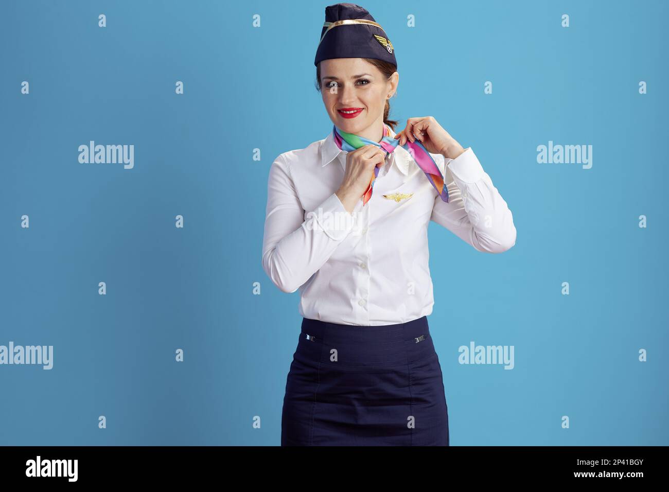 happy stylish air hostess woman isolated on blue background in uniform ...