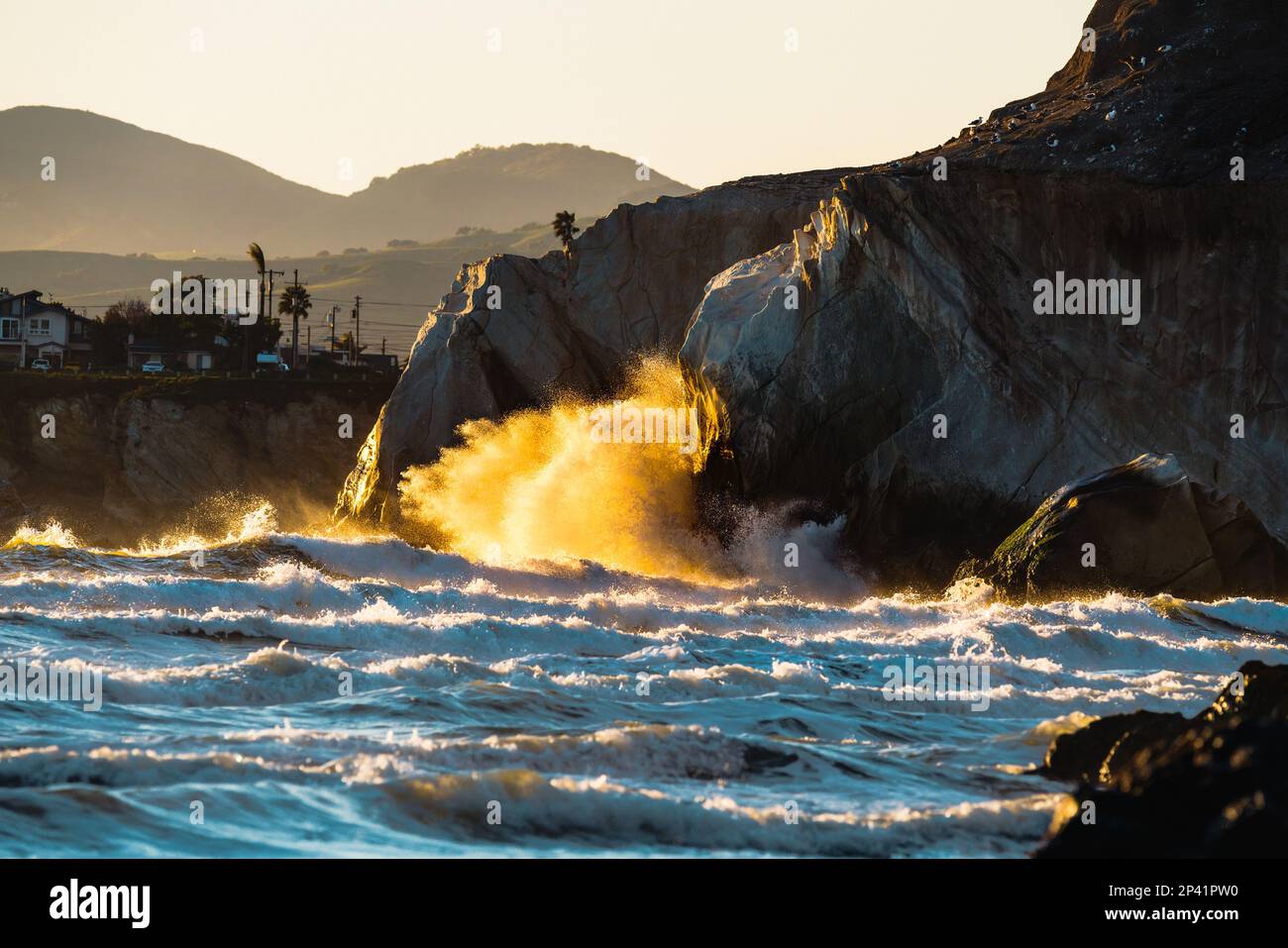 Strong ocean wave hitting the rock in sunset time at Pismo Beach ...