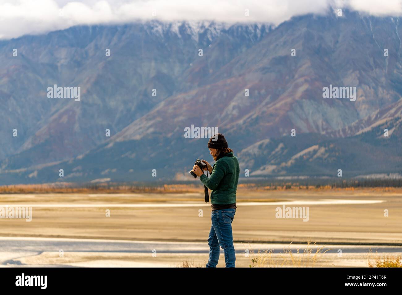 Tourist taking photos along the Alaska Highway during fall, autumn with ...
