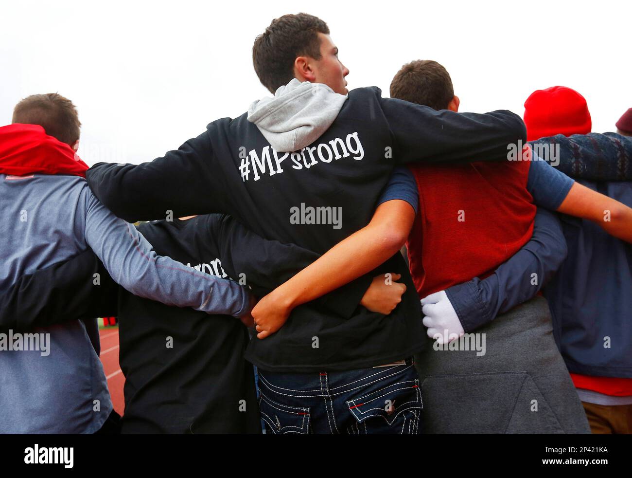 Marysville Pilchuck High School students embrace as they watch a ...