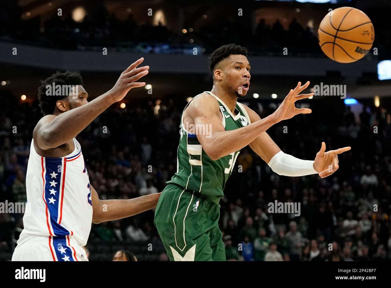 Milwaukee Bucks' Giannis Antetokounmpo passes while being defended by Philadelphia 76ers' Joel ...