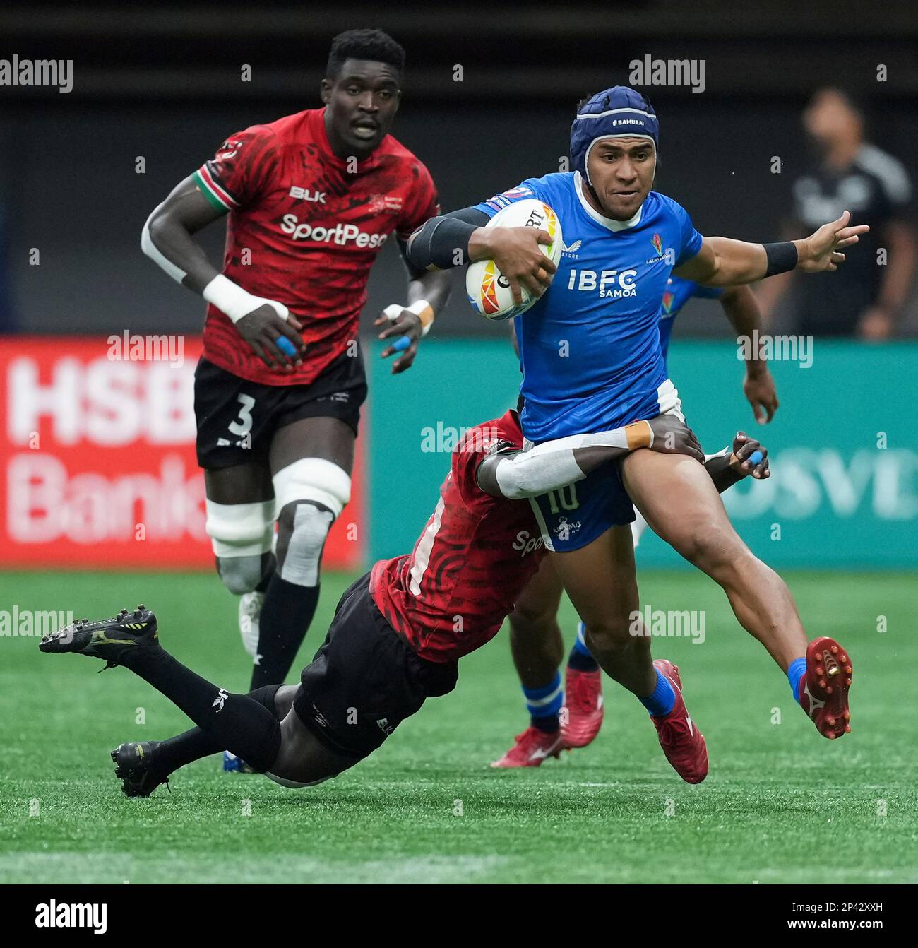 Samoa's Paul Scanlan, front, is tackled by Kenya's Brian Tanga, back ...
