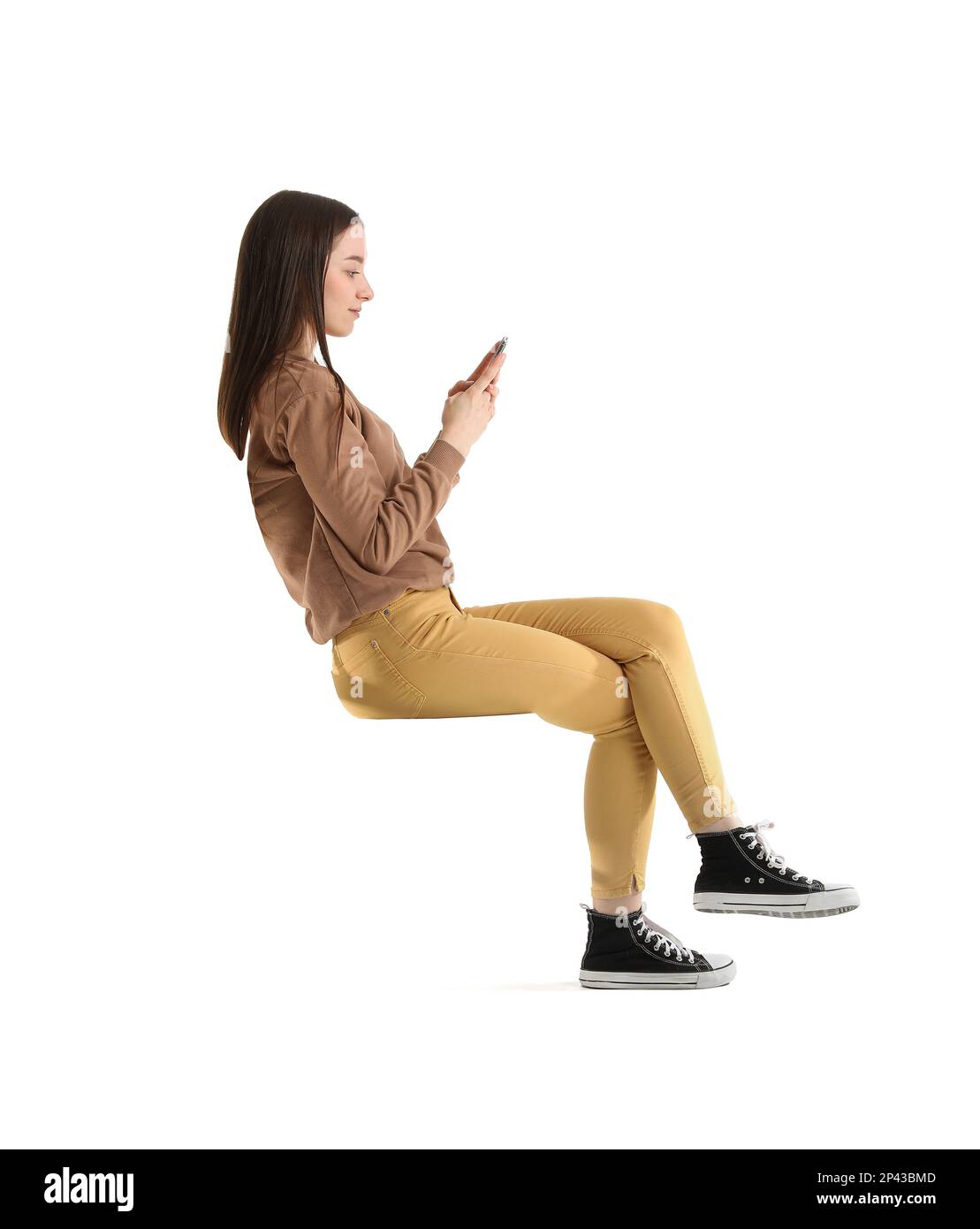 Pretty young woman with smartphone sitting on chair against white ...