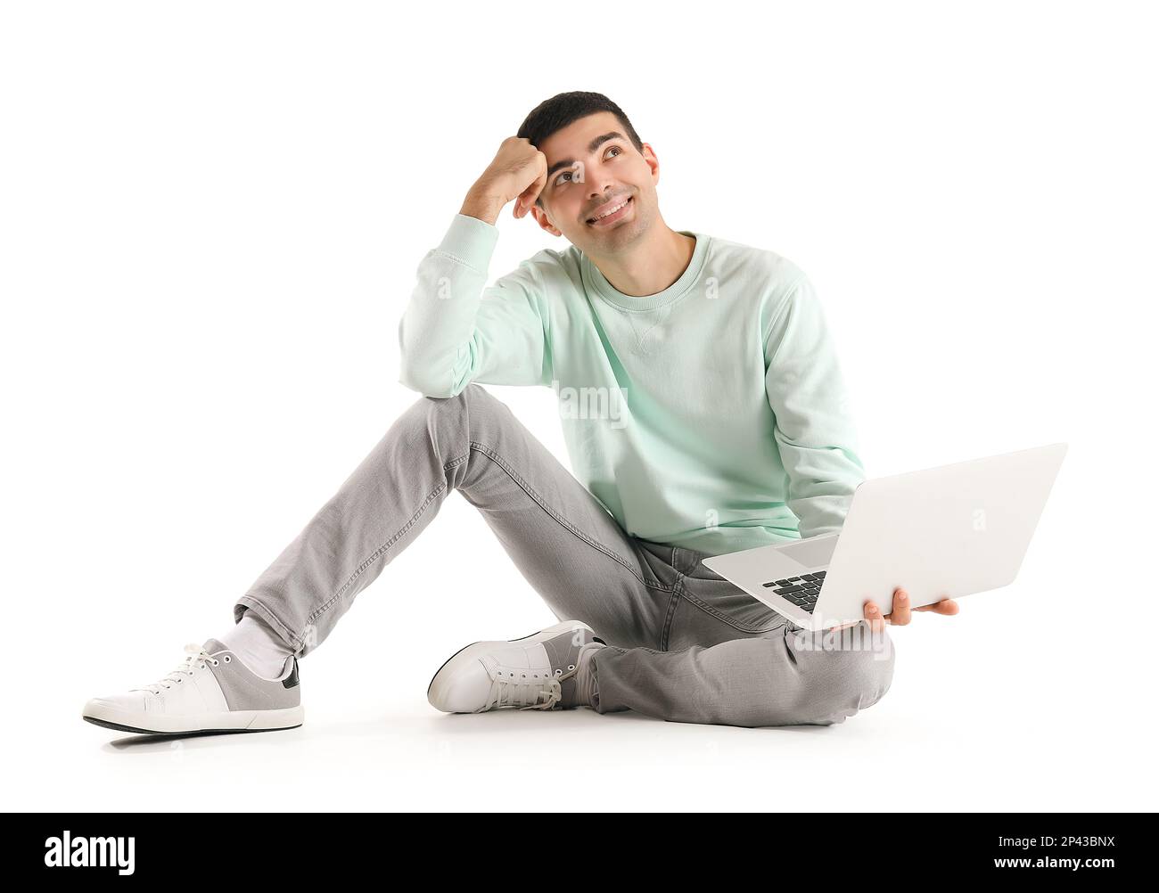 Handsome guy with laptop sitting on white background Stock Photo - Alamy