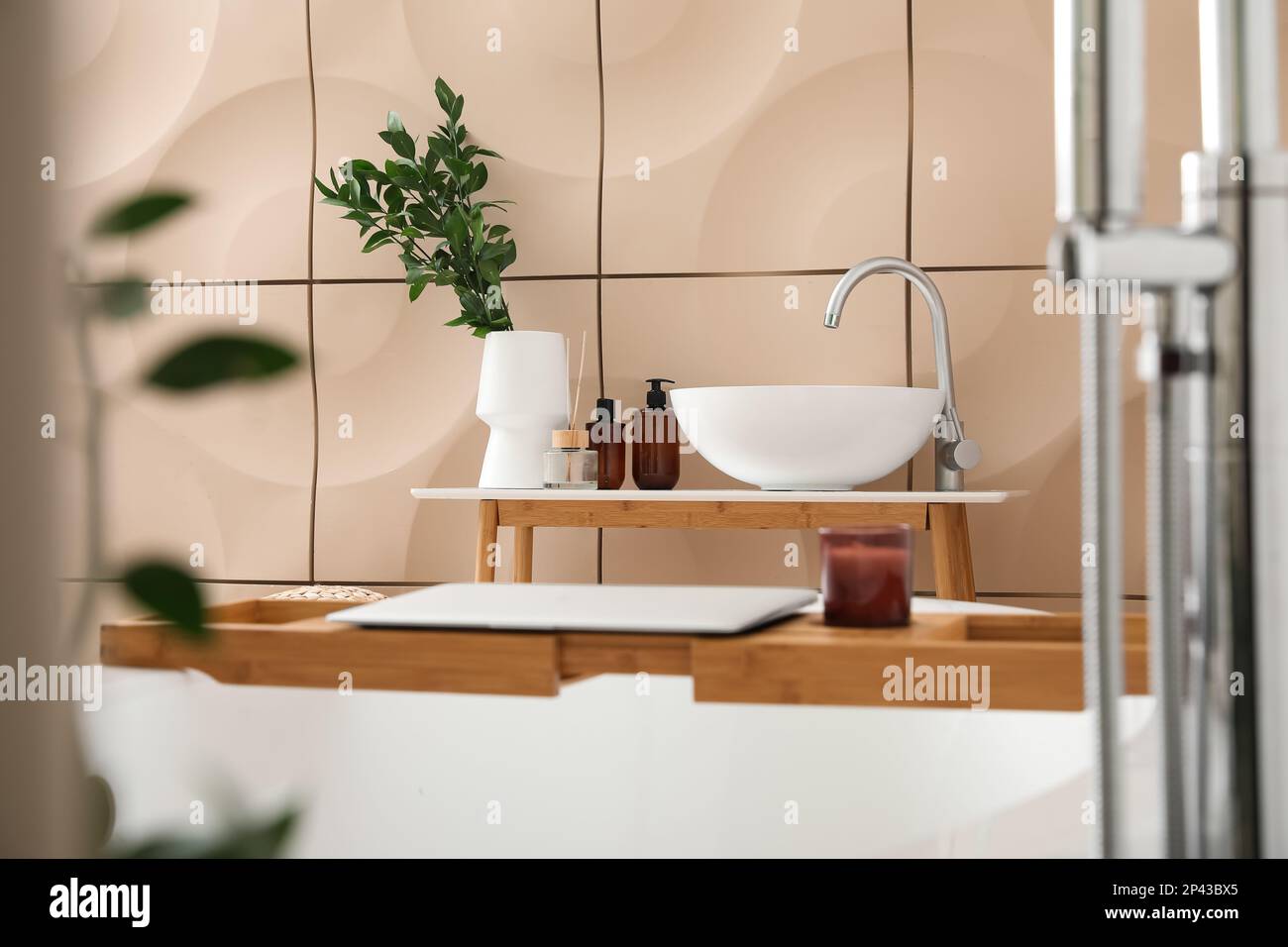 Interior of bathroom with modern bathtub, ceramic sink and laptop on ...