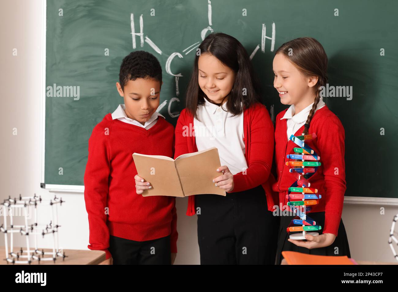Little children with copybook and molecular model in science classroom ...