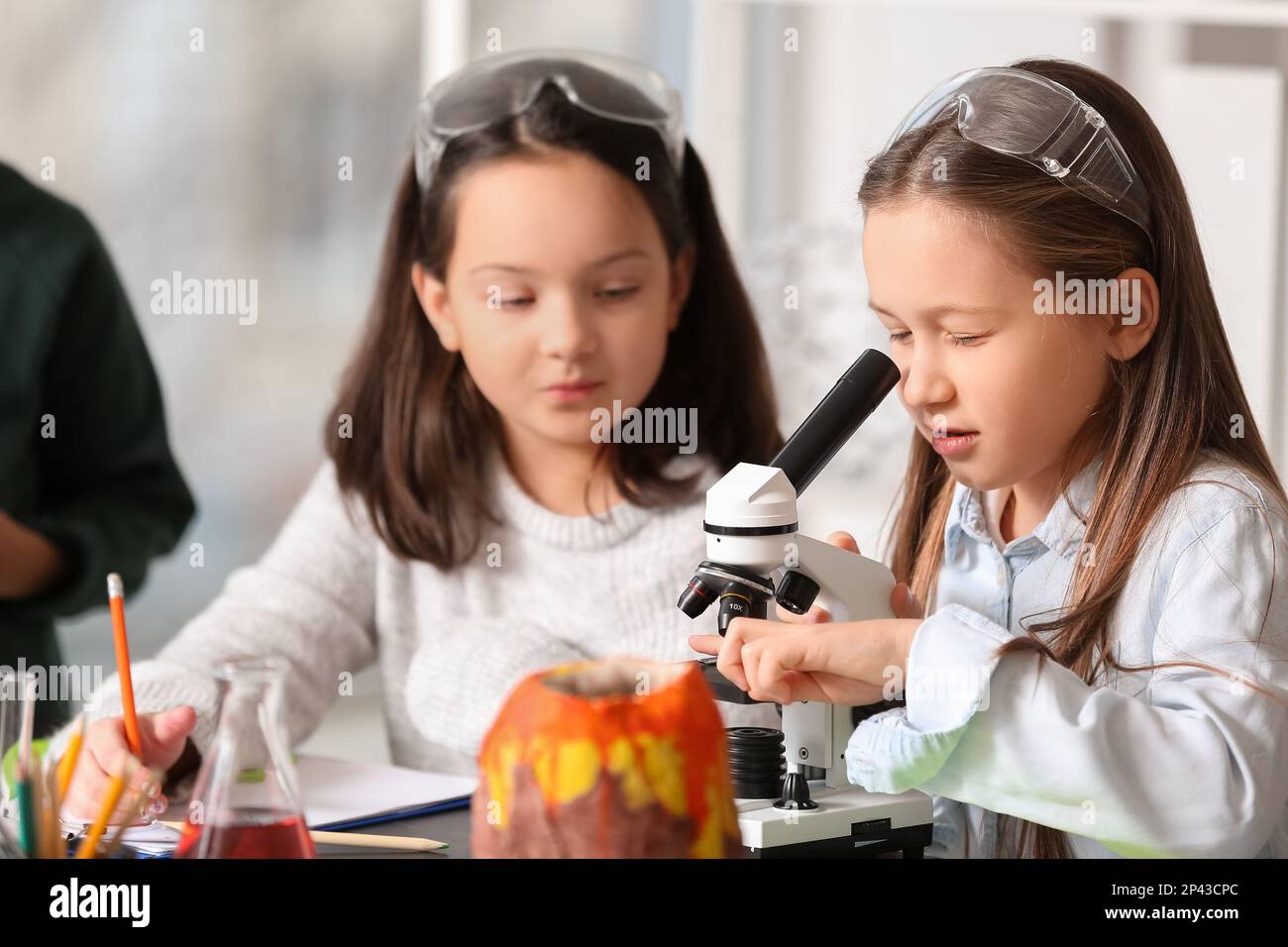Cute little children with microscope in science classroom Stock Photo ...