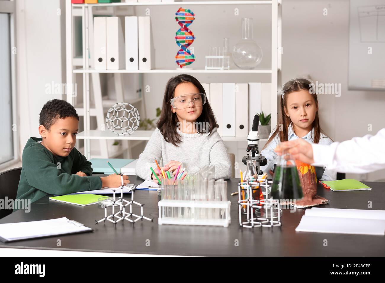 Cute little children with teacher having Chemistry in science classroom ...