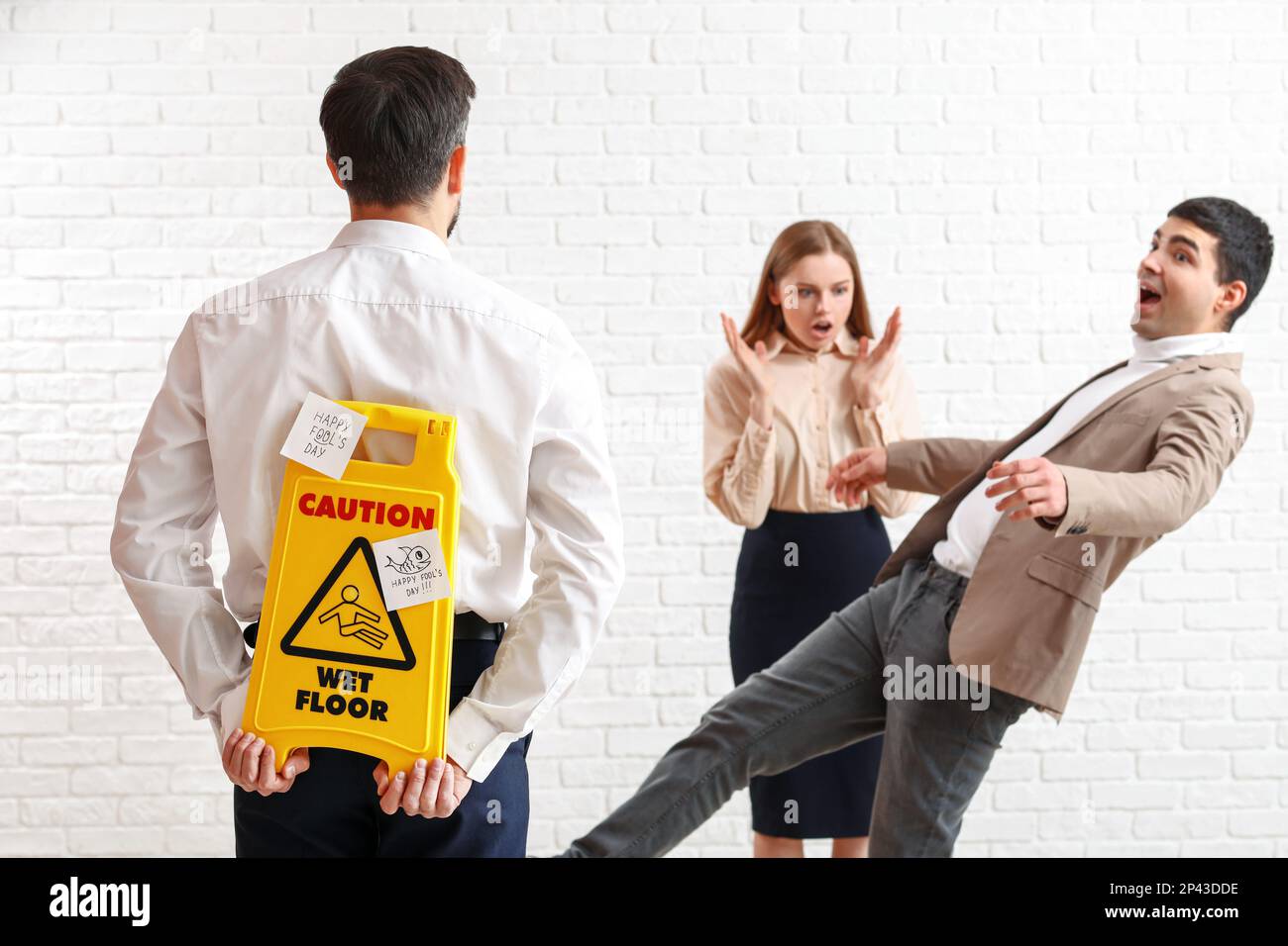 Young man with caution sign playing a prank on his colleagues against ...