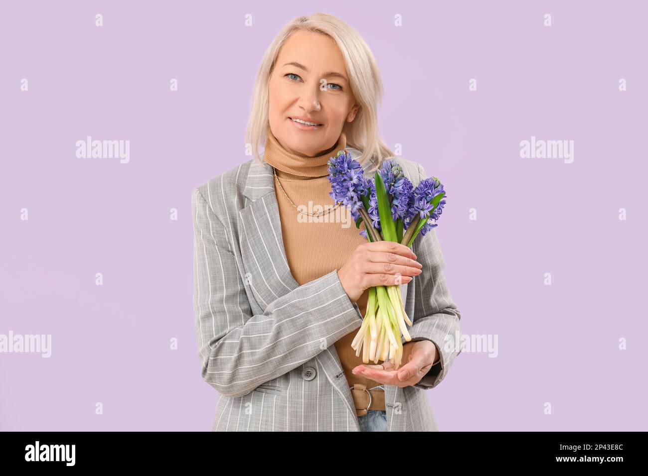 Beautiful mature woman with bouquet of hyacinth flowers on lilac ...