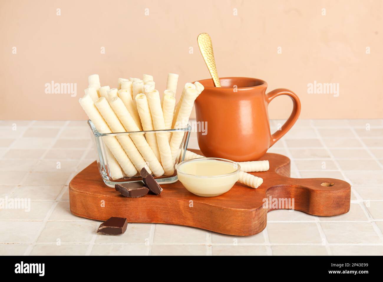 Board with delicious wafer rolls, condensed milk and chocolate pieces ...