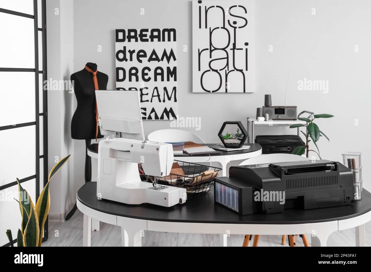 Interior of modern atelier with tables and mannequin Stock Photo - Alamy