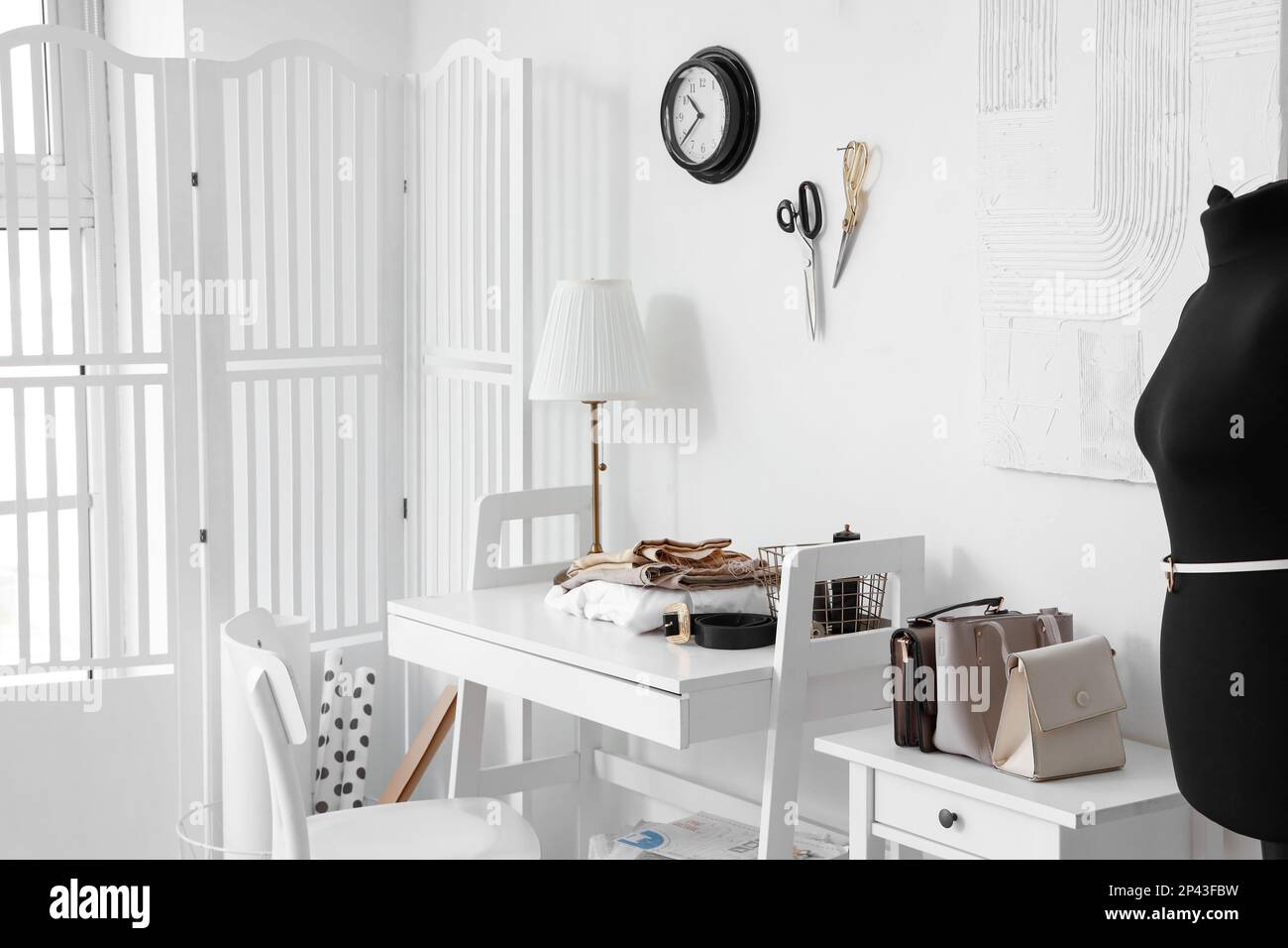 Interior of modern atelier with tailor's workplace and folding screen ...