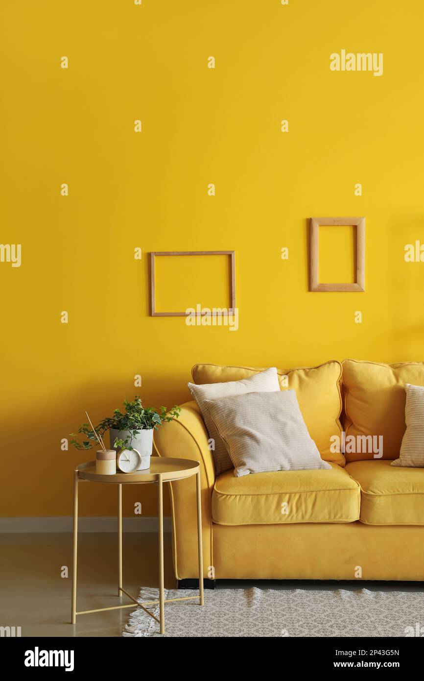 Interior of living room with yellow sofa and table Stock Photo - Alamy