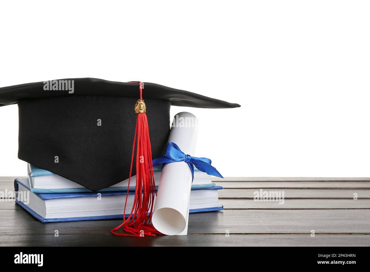 Graduation hat with diploma and books on dark wooden table against ...