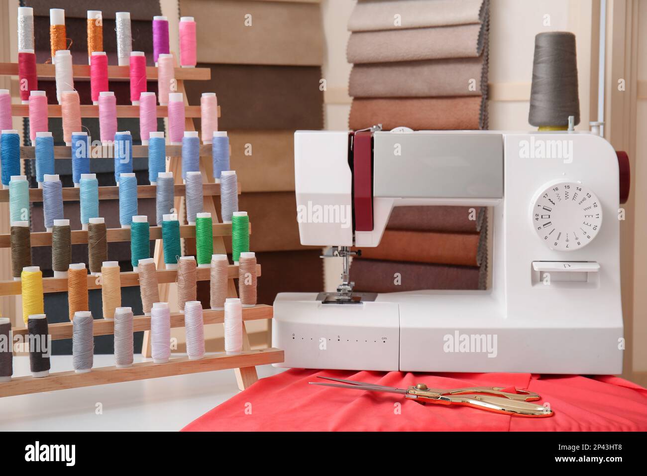 Tailor's workplace with sewing machine, thread spools and fabric ...