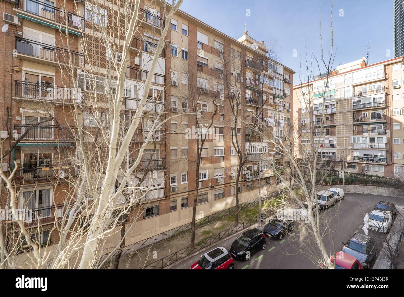 facades of urban residential buildings on streets with parked vehicles ...