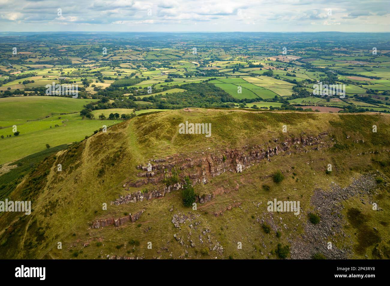 Aerial view of the summit of a small mountain surrounded by farmland ...