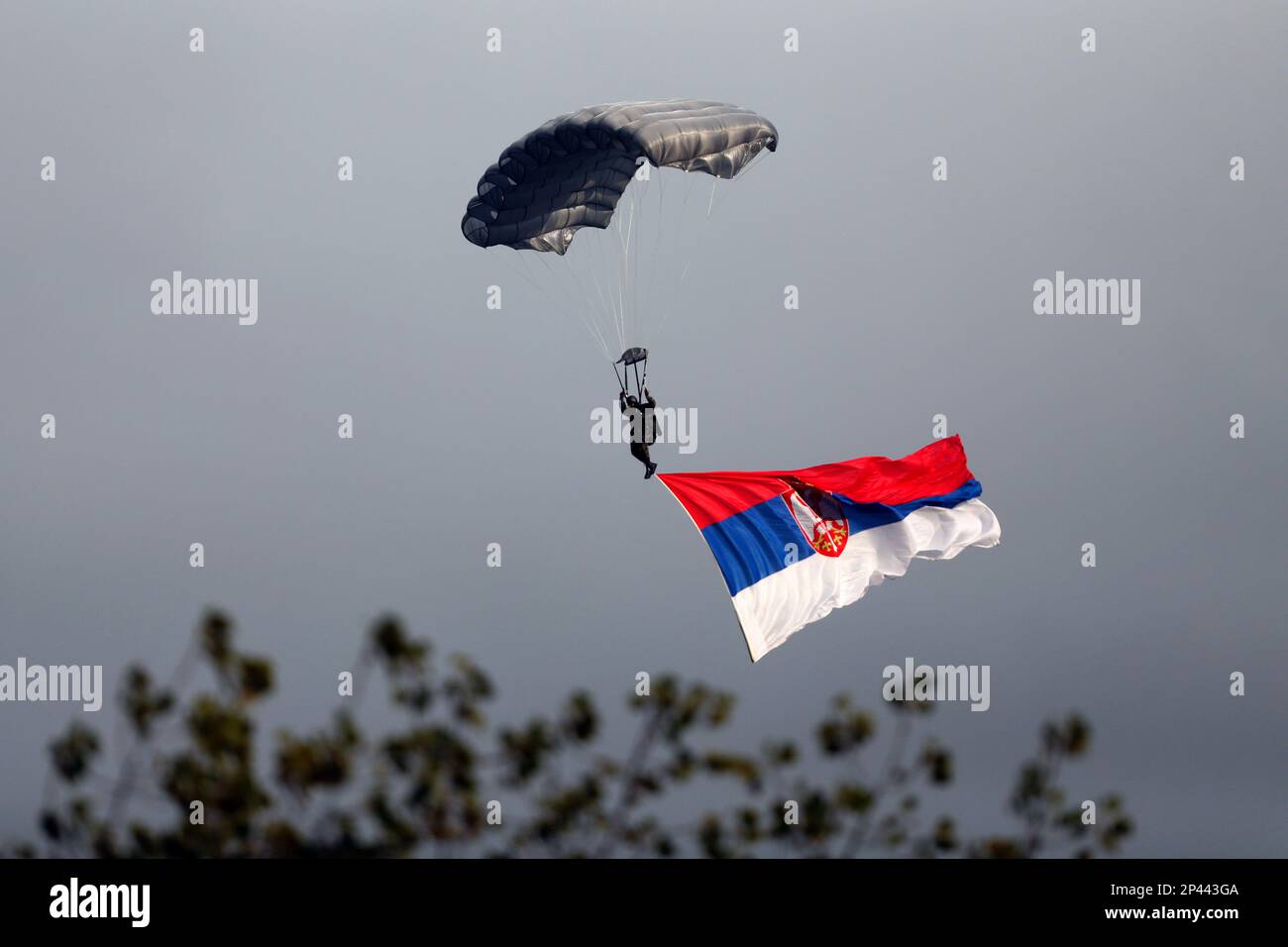 A Serbian army paratrooper descends during a military parade in ...