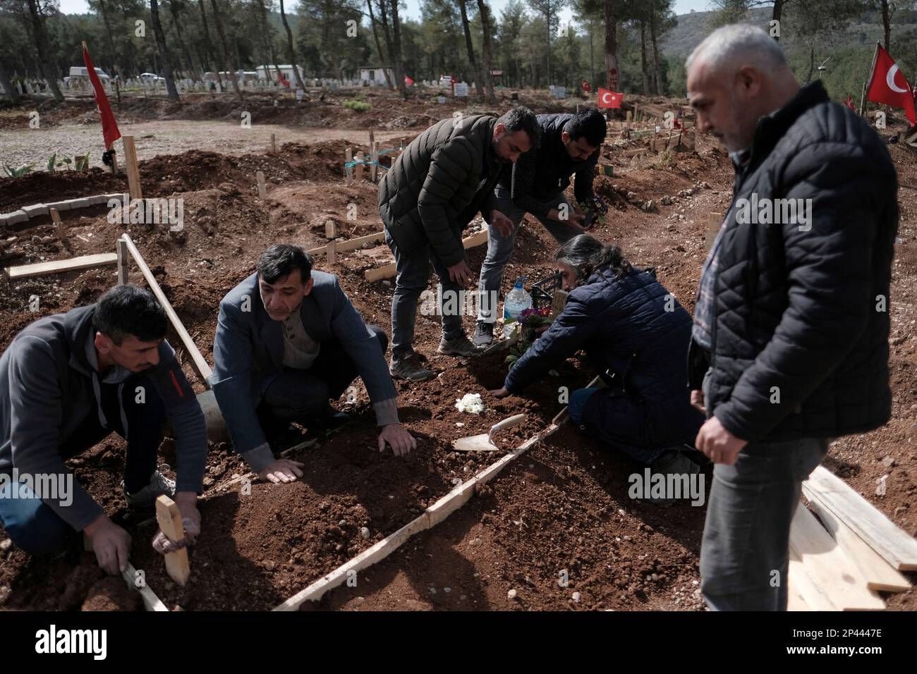 People mourn at a mass grave where earthquake victims were buried in ...