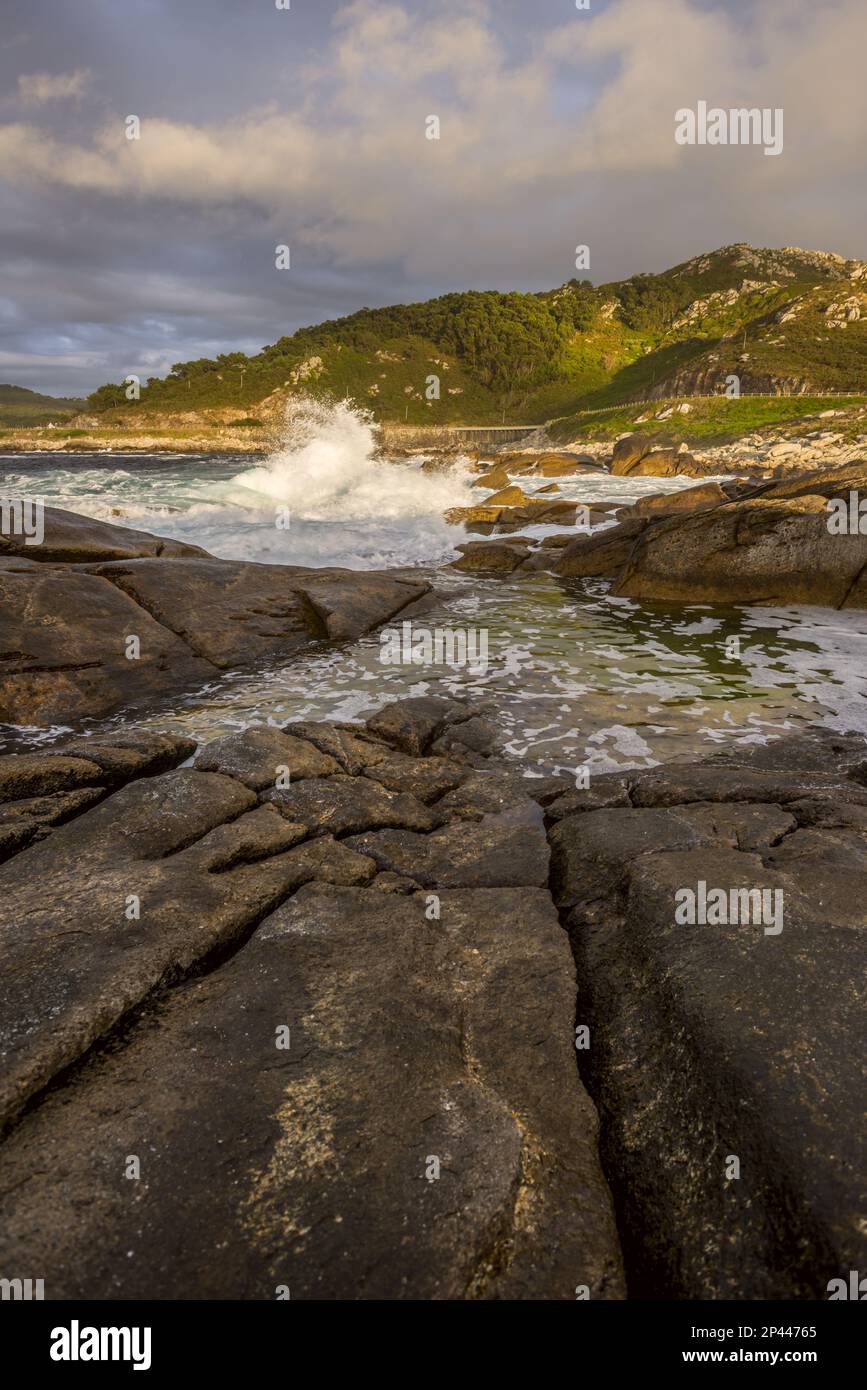 Sunset on the Galician coast of the lower estuaries next to large breakwaters of granodiorite ...