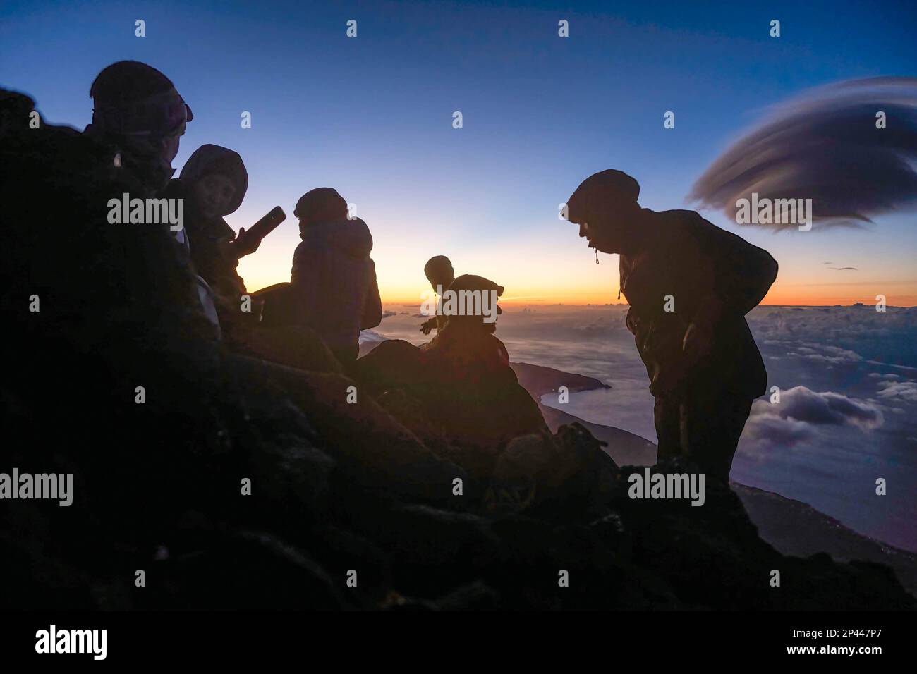Hikers seen on the Pico mountain summit during sunrise, in the Azores ...