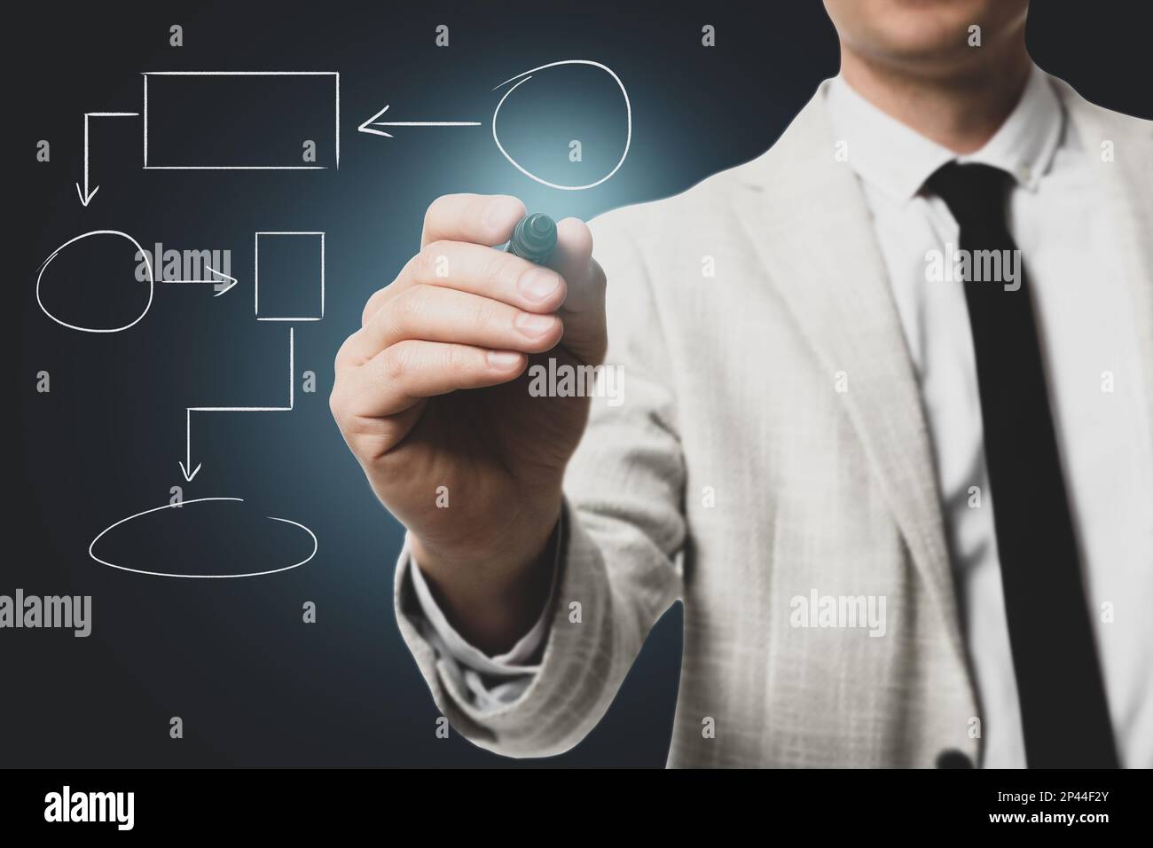 Man pointing at flowchart on virtual screen against dark background ...