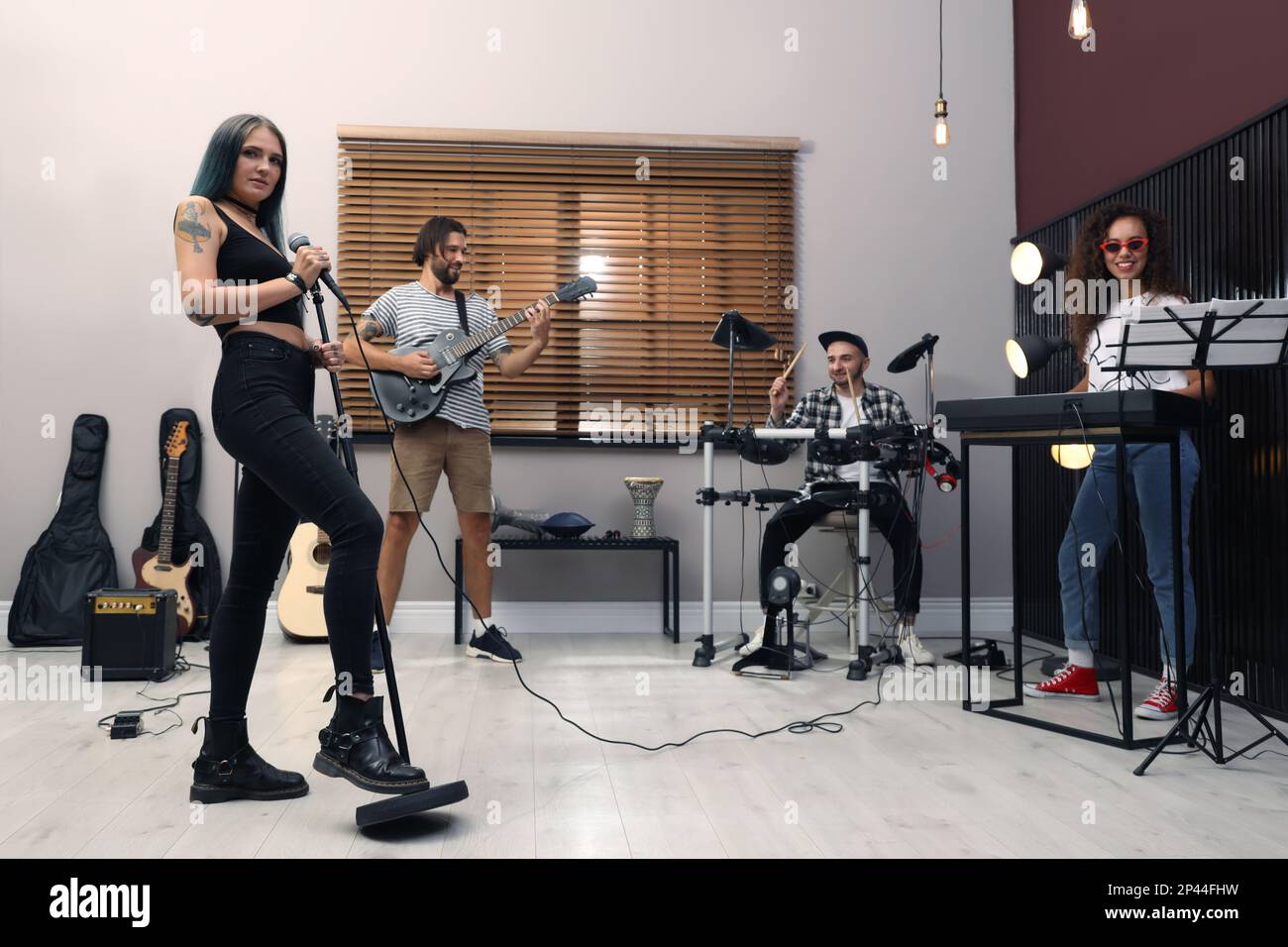 Music band performing in modern recording studio Stock Photo - Alamy