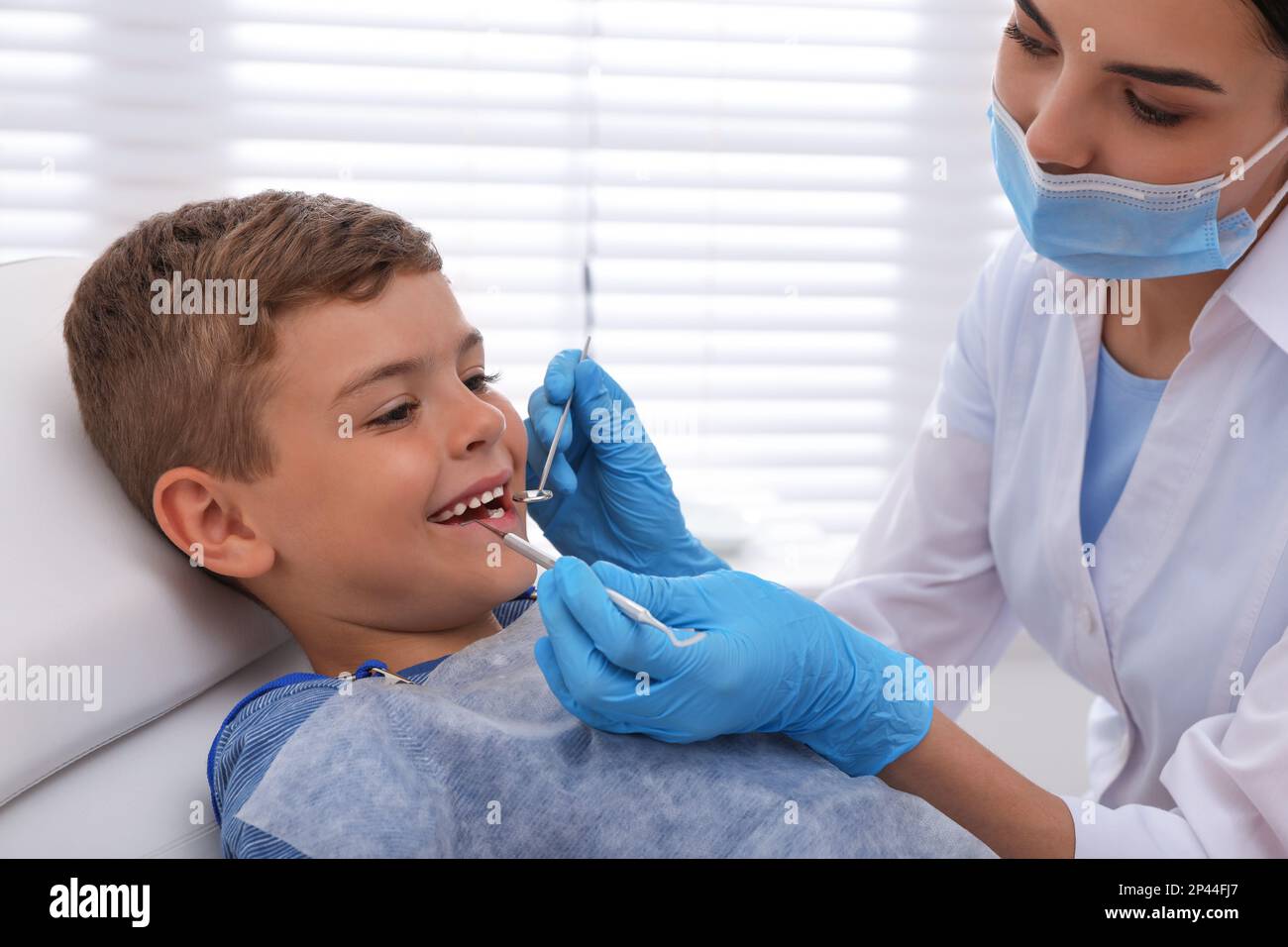 Dentist examining little boy's teeth in modern clinic Stock Photo - Alamy