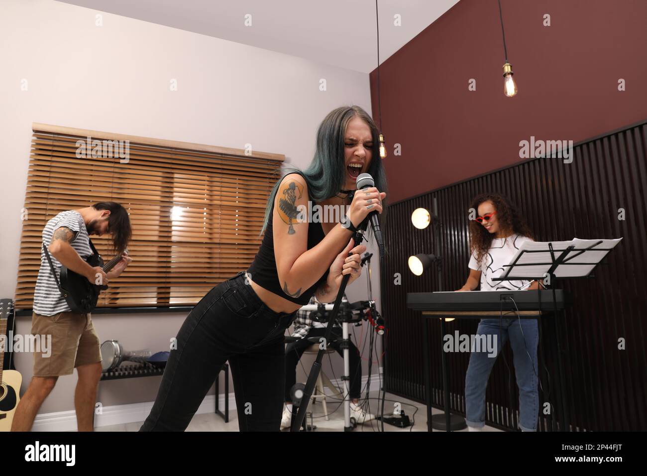 Music band performing in modern recording studio Stock Photo - Alamy