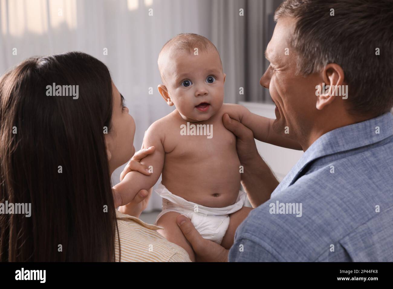 Happy family with their cute baby at home Stock Photo - Alamy