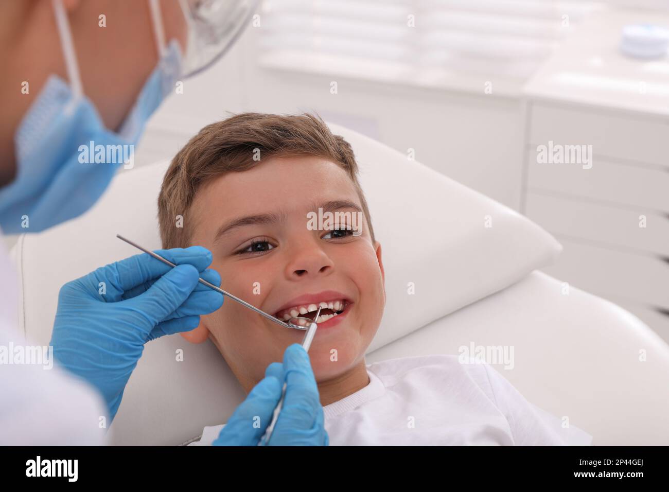 Dentist examining little boy's teeth in modern clinic Stock Photo - Alamy