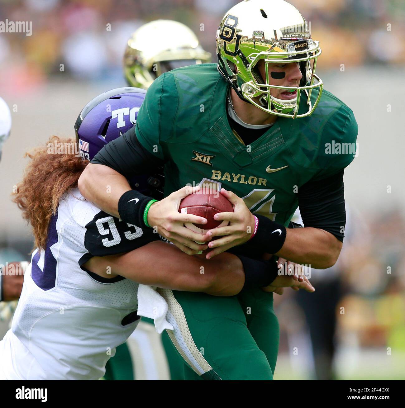 Baylor quarterback Bryce Petty (14) is pulled down by TCU defensive end ...