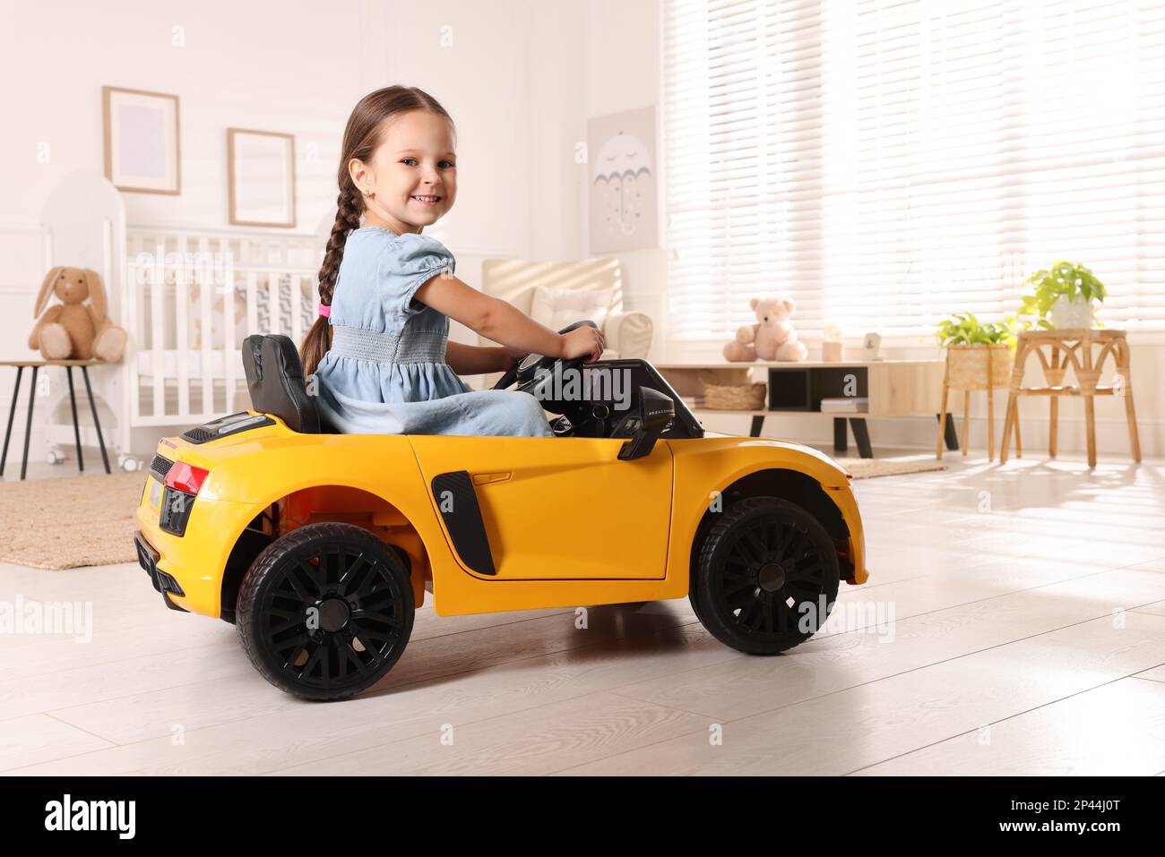 Adorable child driving toy car in room at home Stock Photo - Alamy