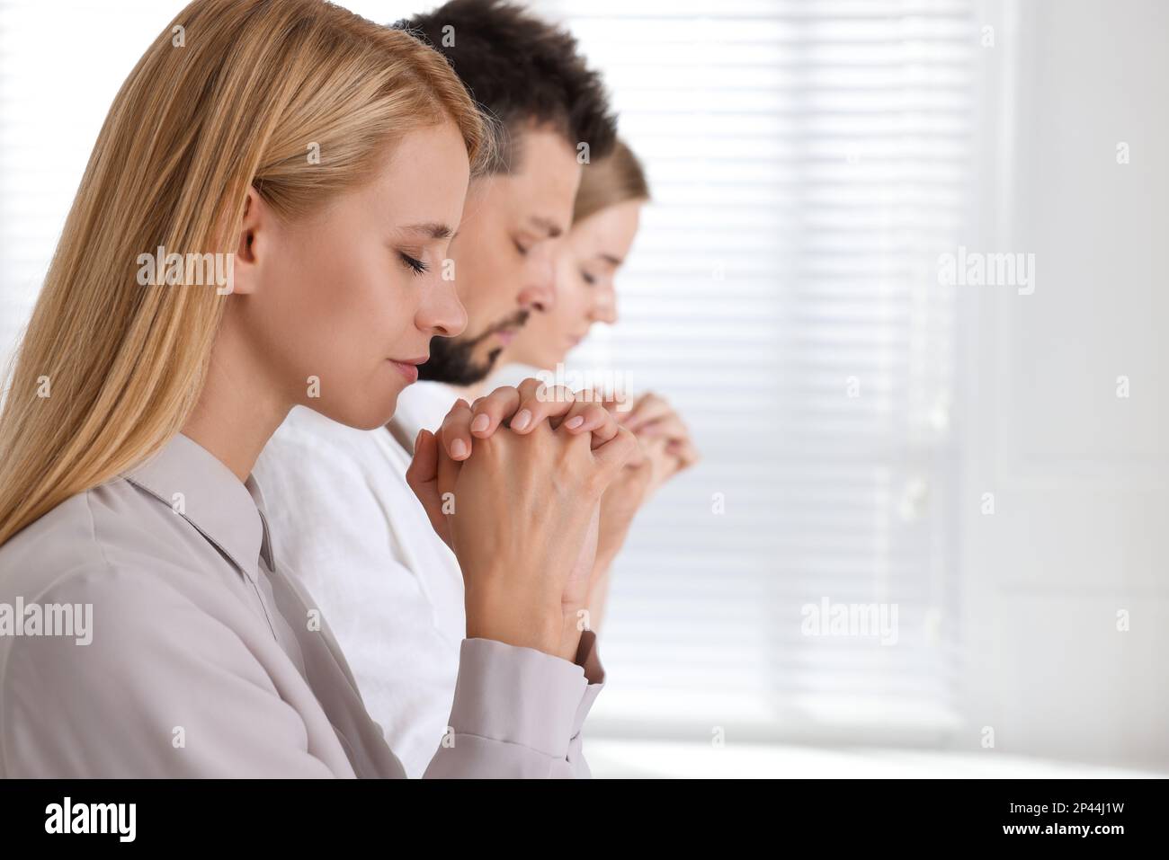 Group of religious people praying together indoors. Space for text ...