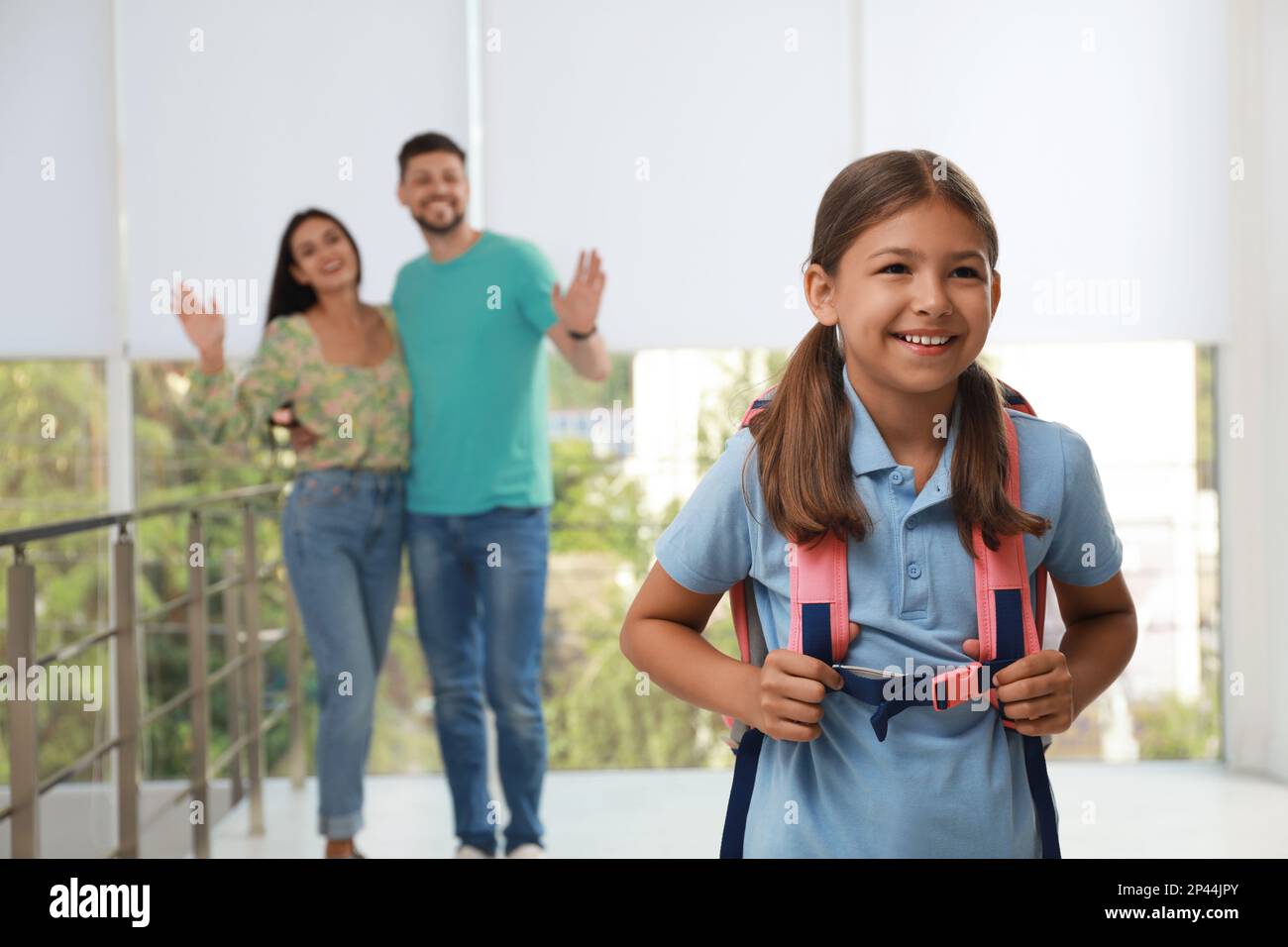 Parents waving goodbye to their daughter in school Stock Photo - Alamy