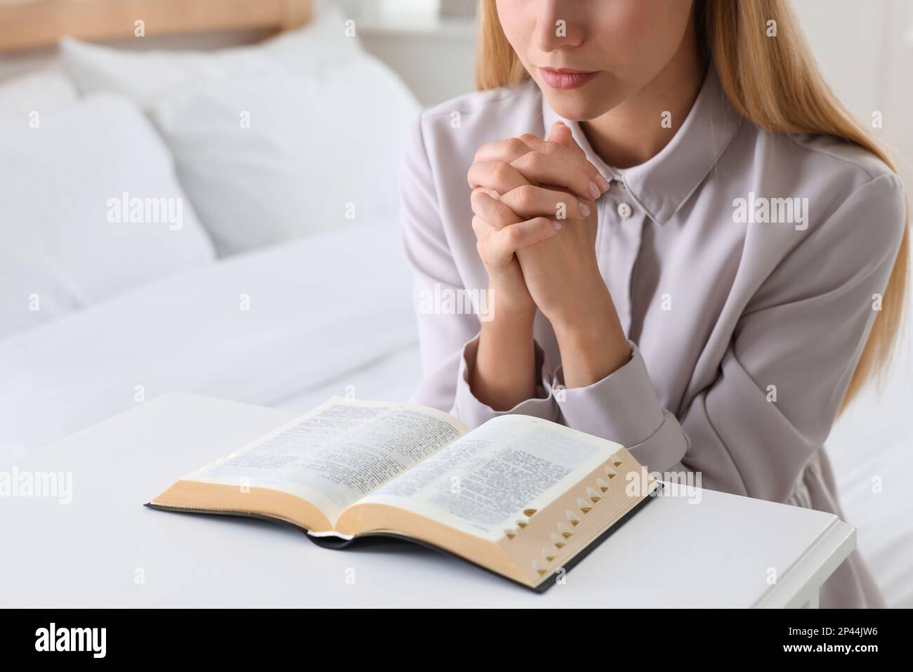Religious young woman with Bible praying in bedroom, closeup Stock ...