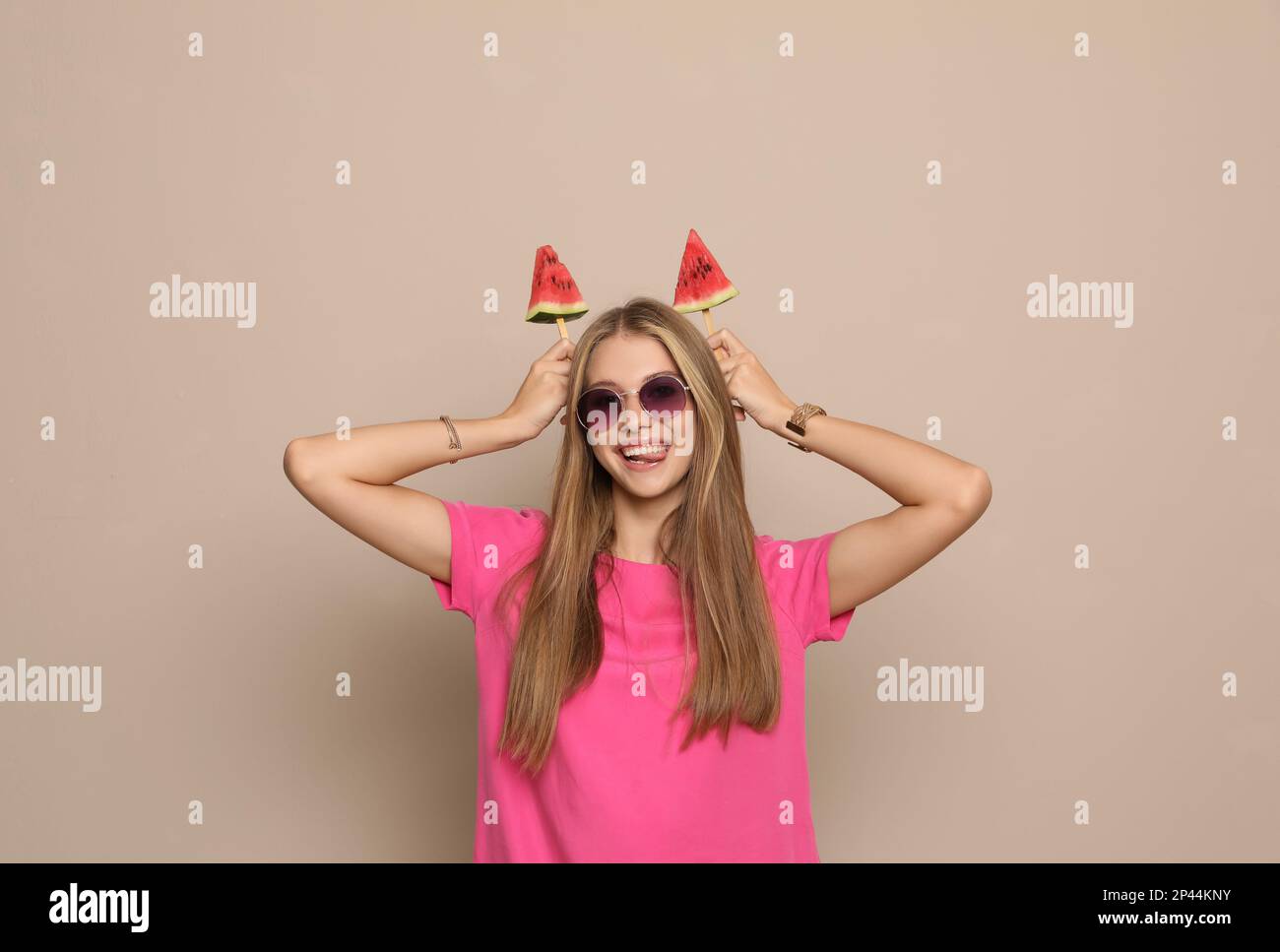 Beautiful girl with pieces of watermelon on beige background Stock ...