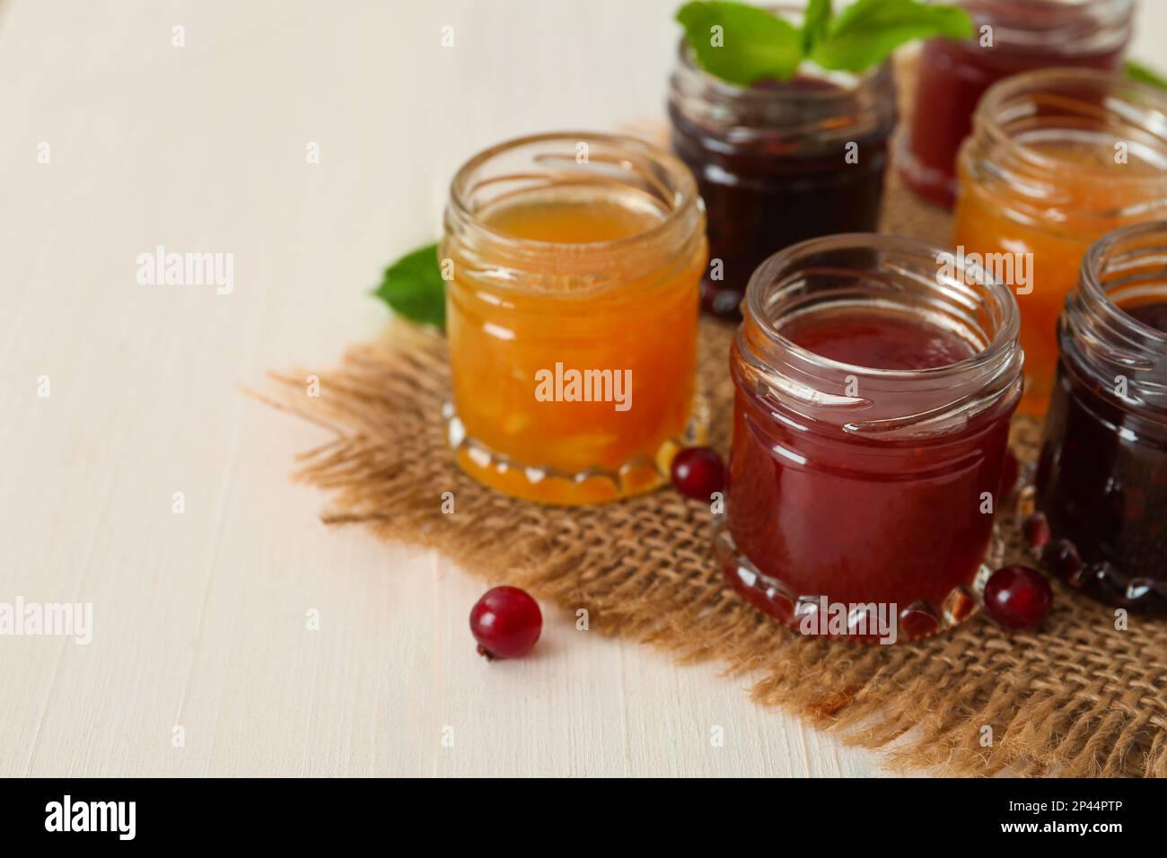 Jars of different jams on white table, space for text Stock Photo - Alamy