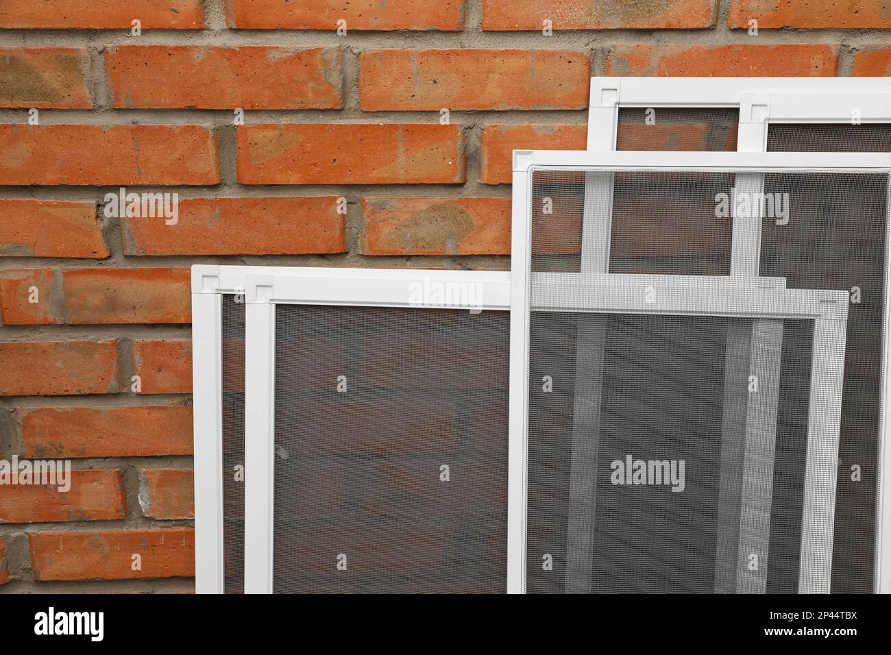 Set of window screens near brick wall. Space for text Stock Photo - Alamy