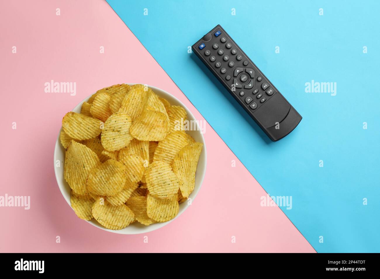 Modern tv remote control and chips on color background, flat lay Stock ...