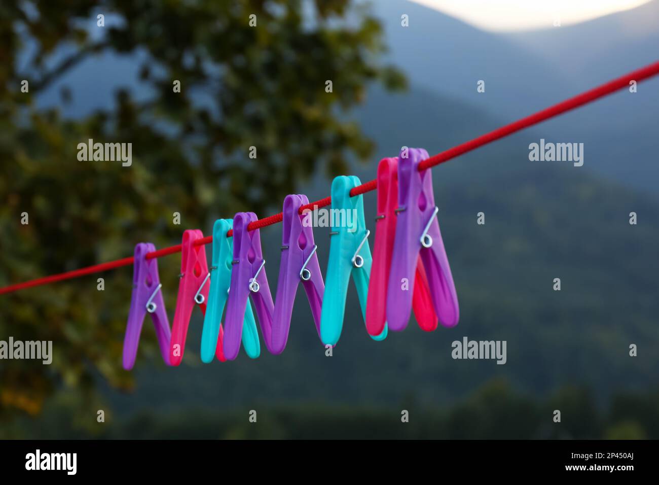 Colorful clothespins hanging on washing line outdoors Stock Photo - Alamy