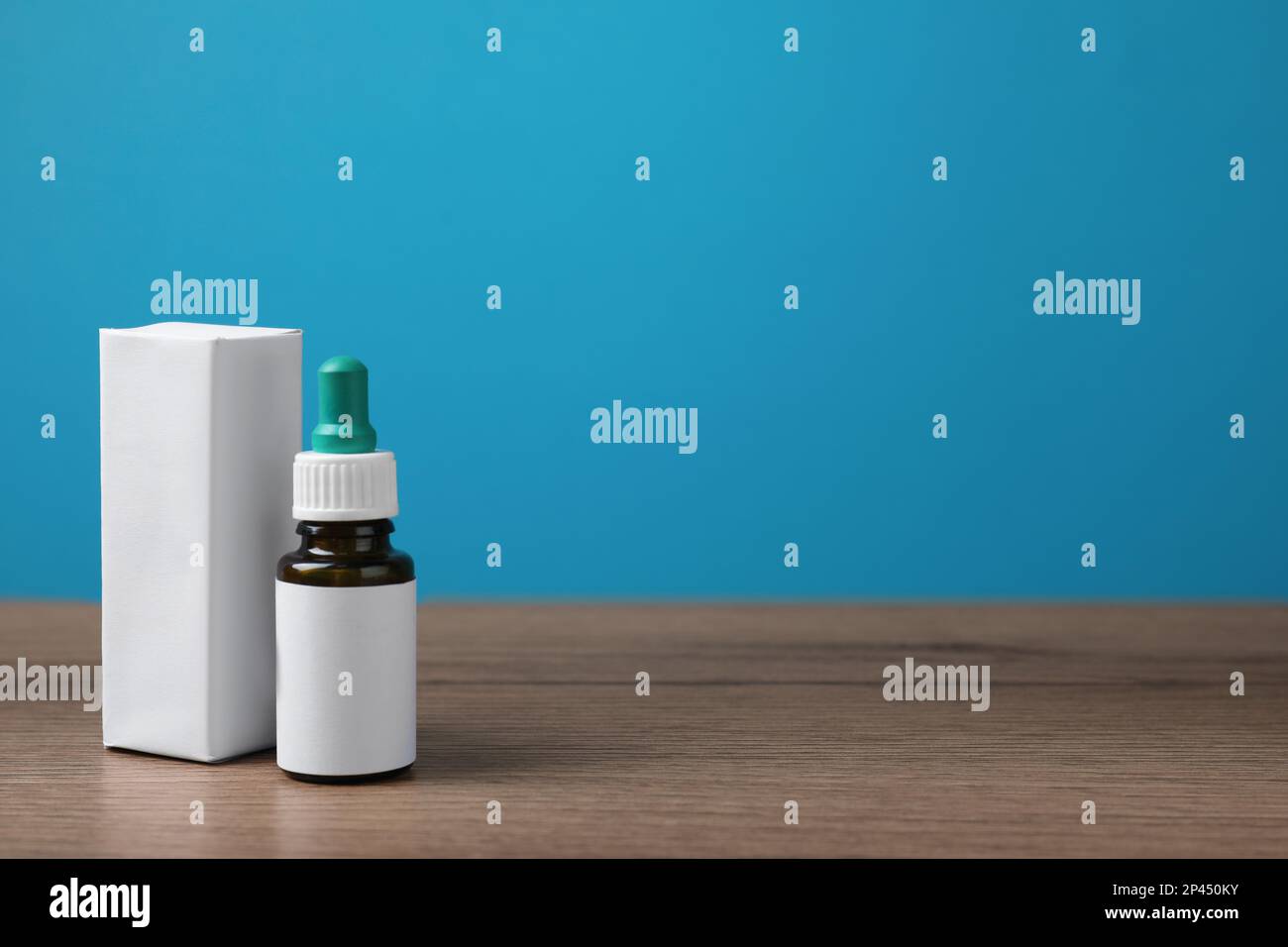 Nasal drops with blank label and package on wooden table against light ...