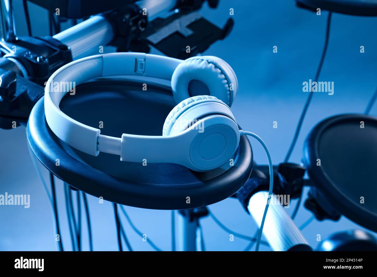 Modern electronic drum kit with headphones on light background, toned ...