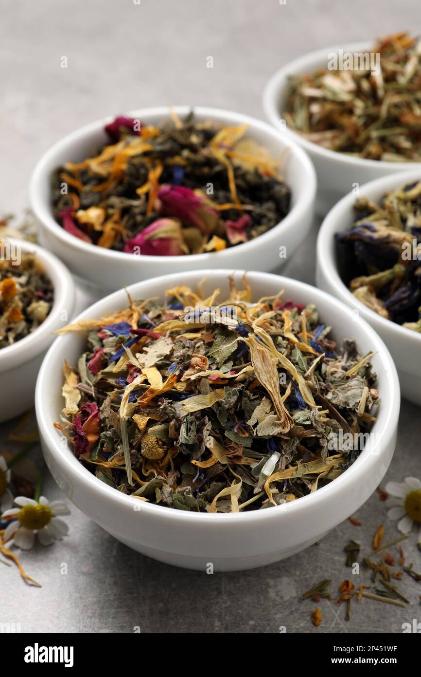 Different dry aromatic teas on light grey table Stock Photo - Alamy