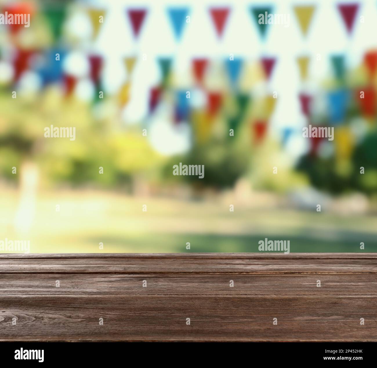 Empty wooden table in park decorated with bunting flags, space for ...