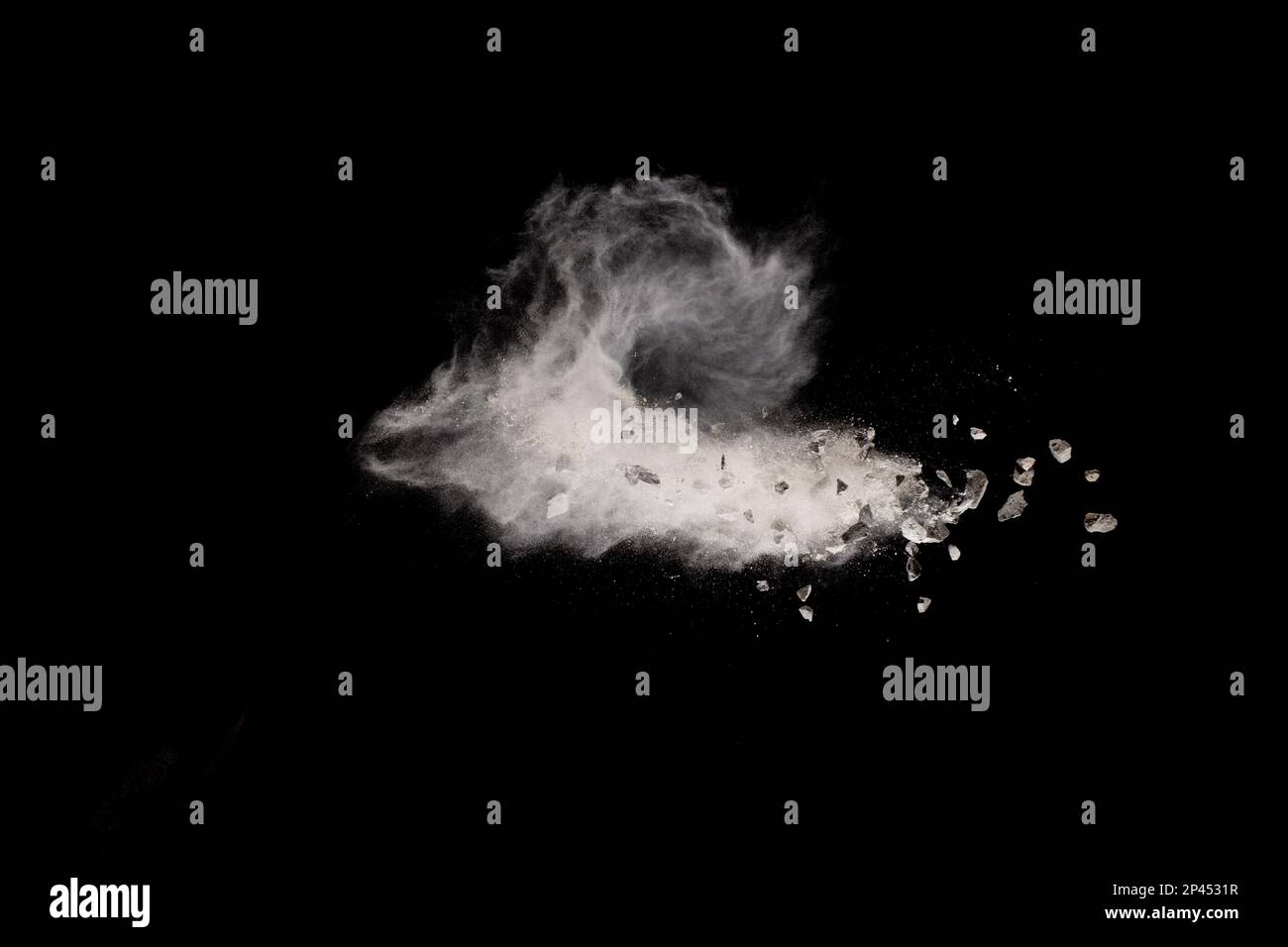 Split debris of stone exploding with white dust against black ...